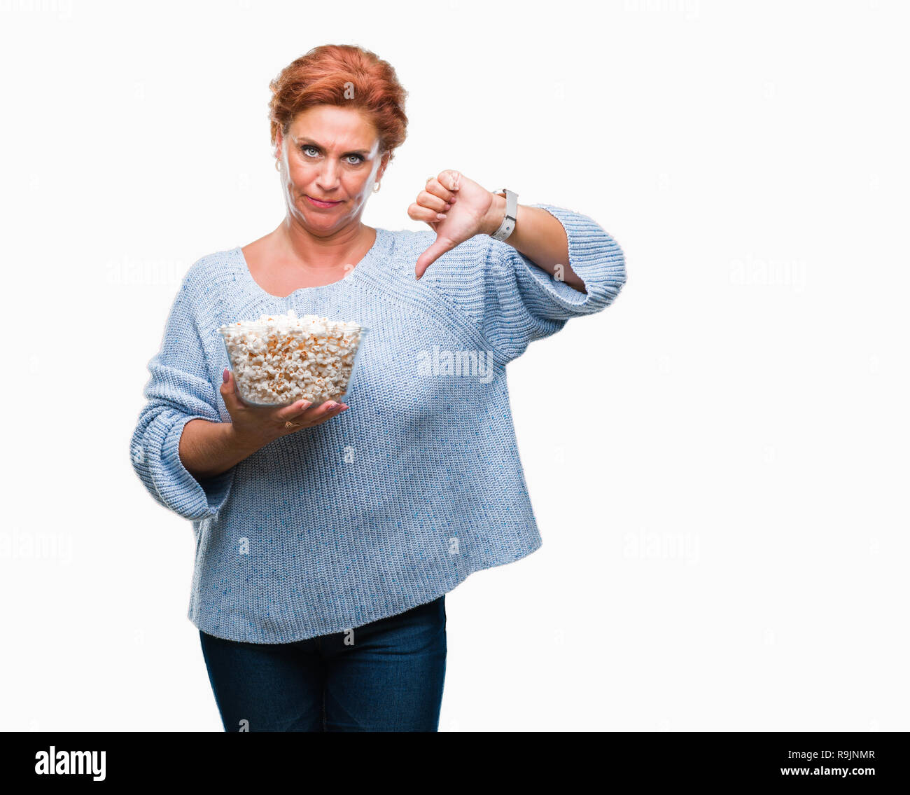 Atrractive Senior Caucasian Redhead Woman Eating Popcorn Over Isolated