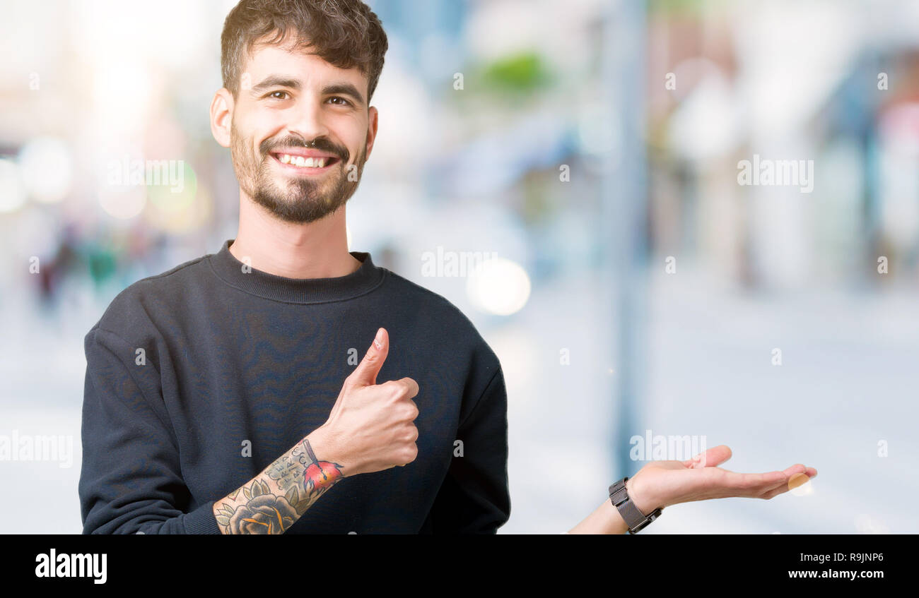 Young handsome man over isolated background Showing palm hand and doing ...