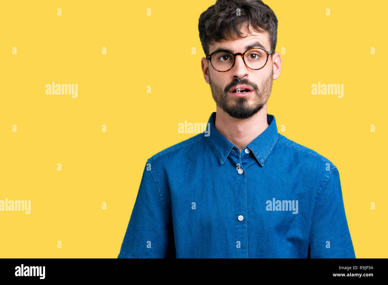 Young handsome man wearing glasses over isolated background afraid and shocked with surprise ...