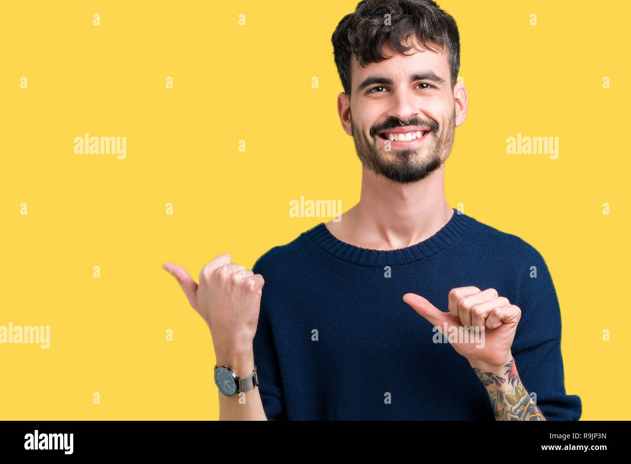 Young handsome man over isolated background Pointing to the back behind ...
