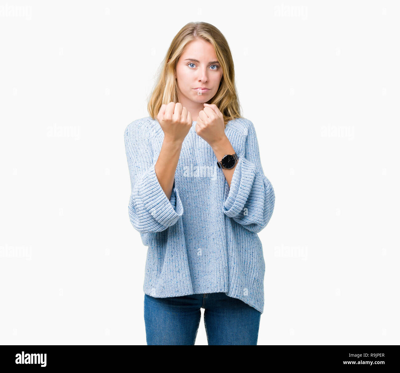 Beautiful young woman wearing blue sweater over isolated background ...