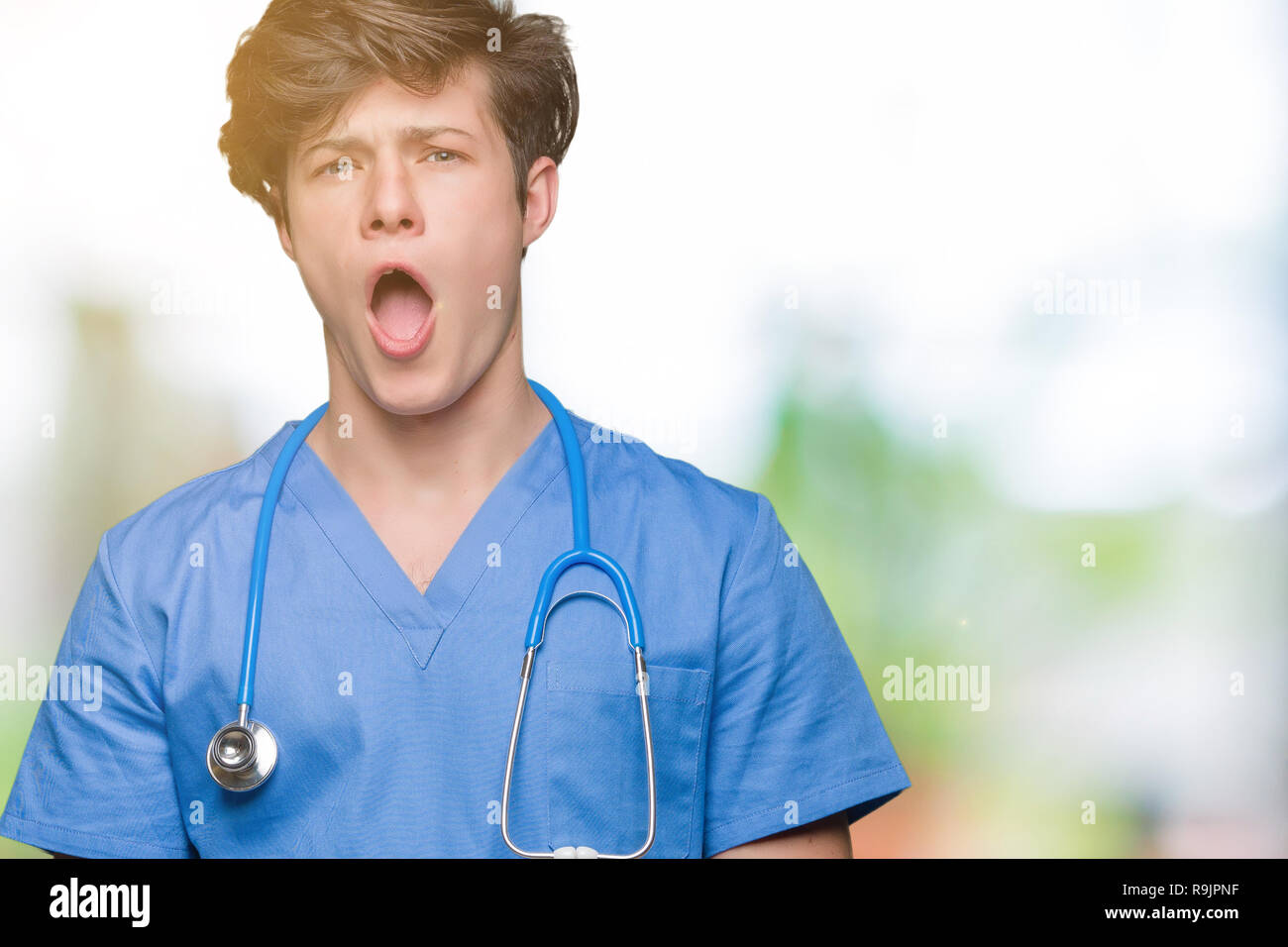 Young doctor wearing medical uniform over isolated background In shock ...