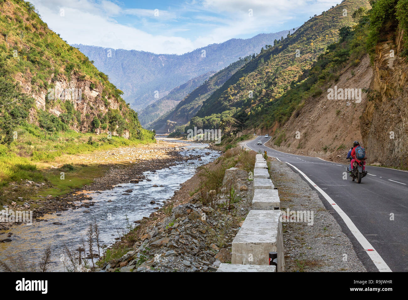 Scenic mountain road with river valley and distant mountain ranges at ...