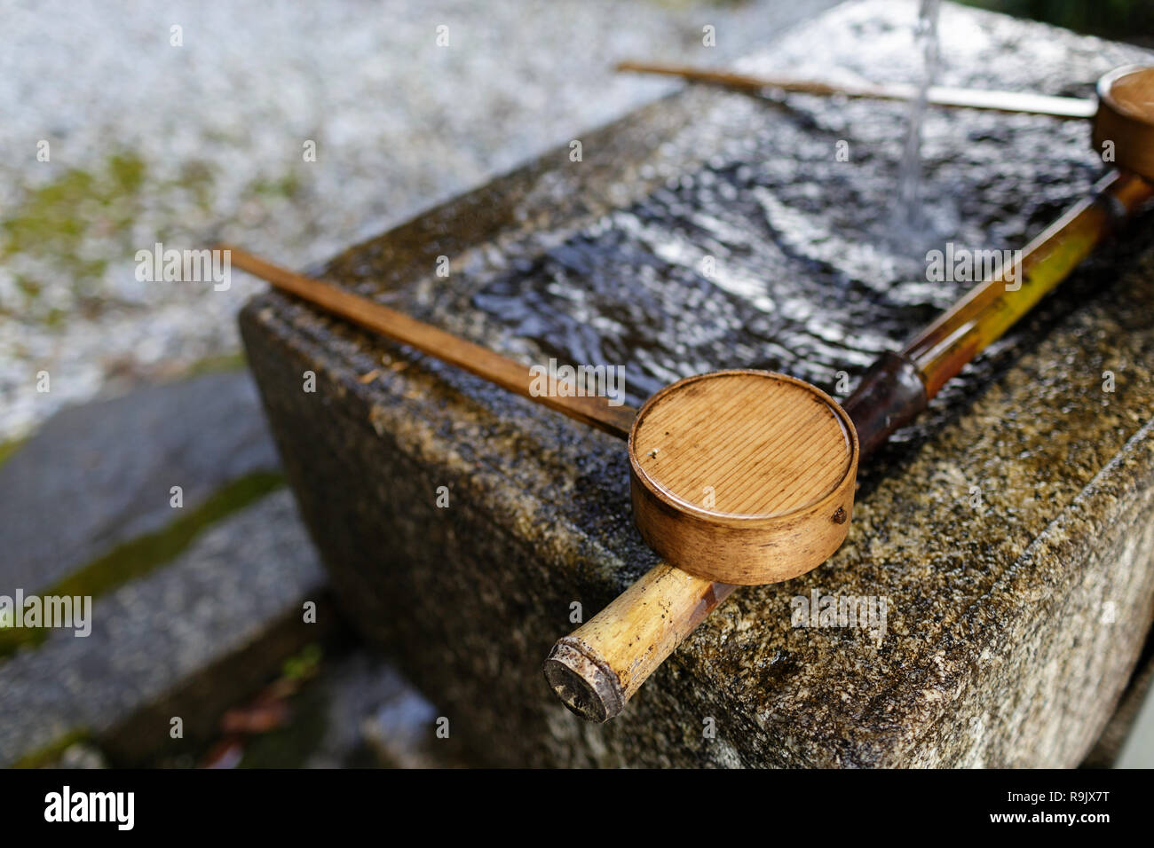 Traditional ancient stone well, a tsukubai (stone water basin) with ...