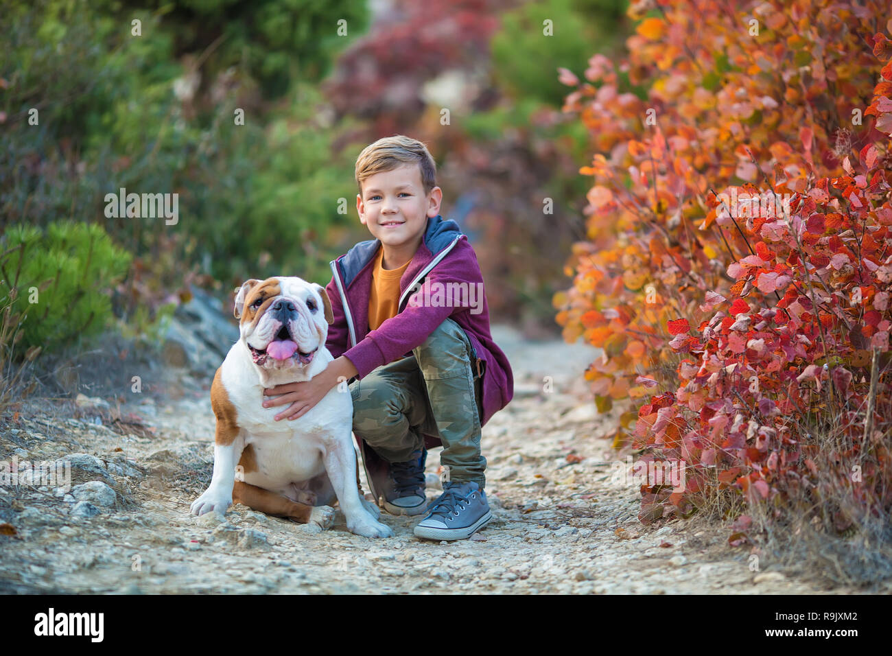 Cute handsome stylish boy enjoying colourful autumn park with his best ...