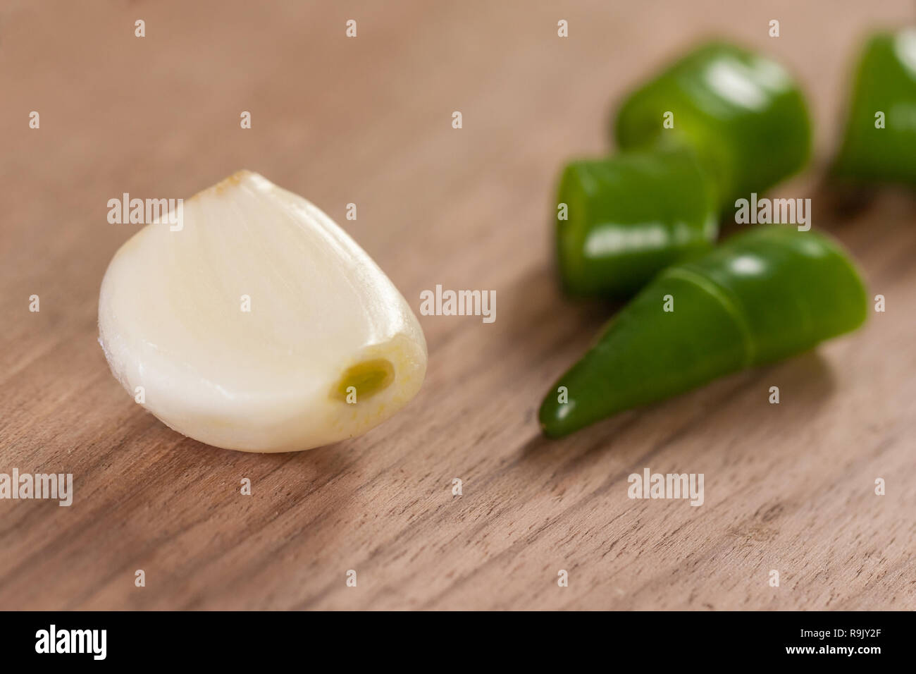 sliced green peppers and garlic on a wooden board Stock Photo - Alamy
