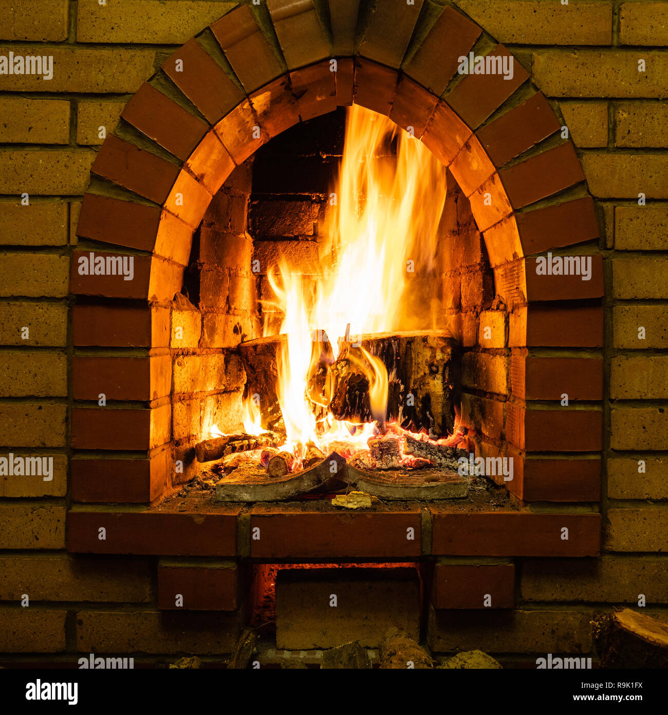 front view of brick fireplace with fire in rural house Stock Photo - Alamy