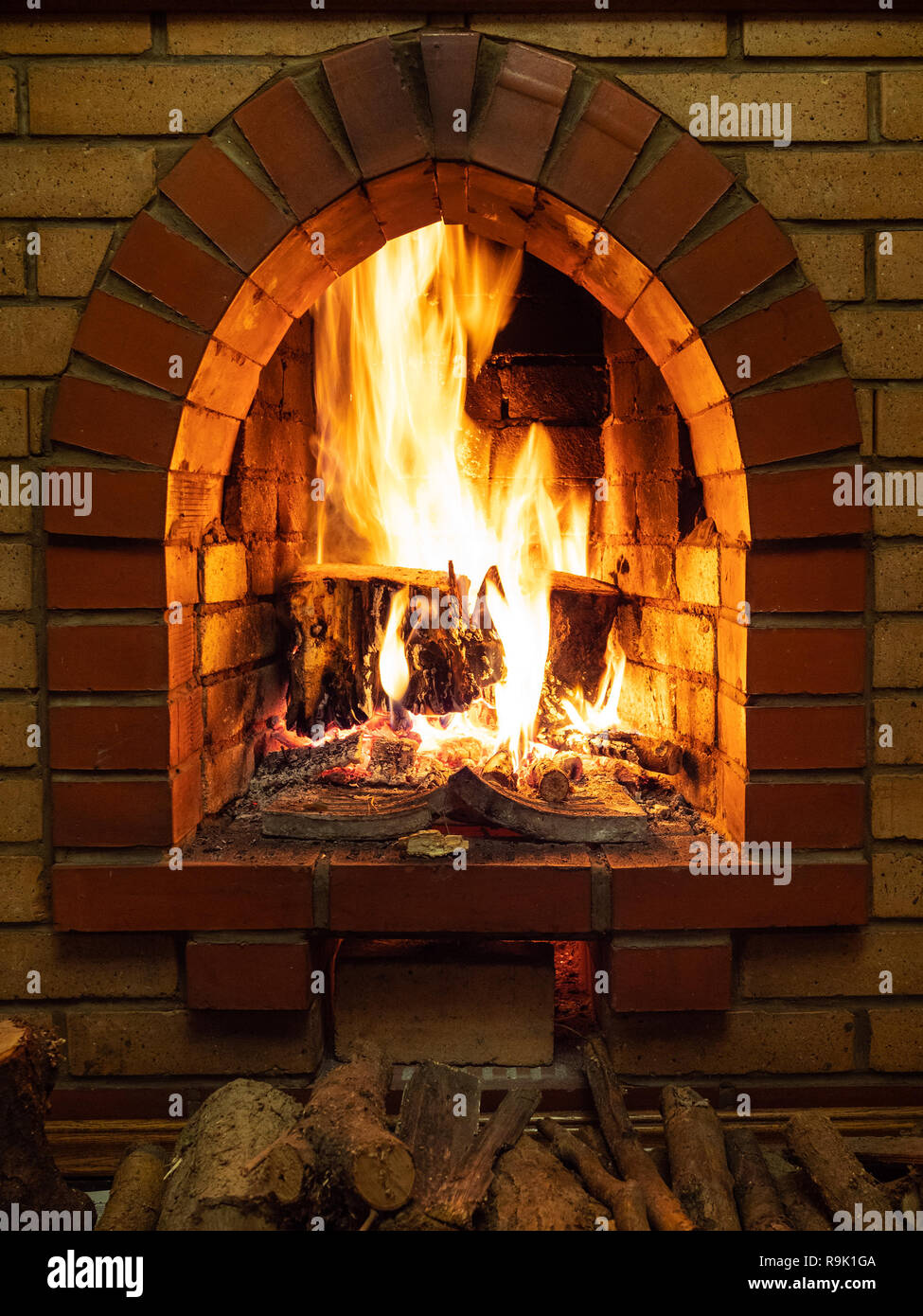 front view of fireplace with fire and firewood in rural house Stock ...