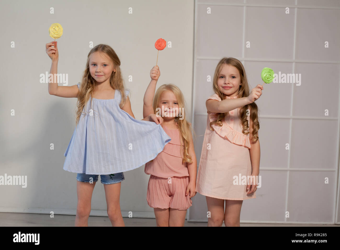 three girlfriends sisters eat sweet lollipop candy Stock Photo - Alamy
