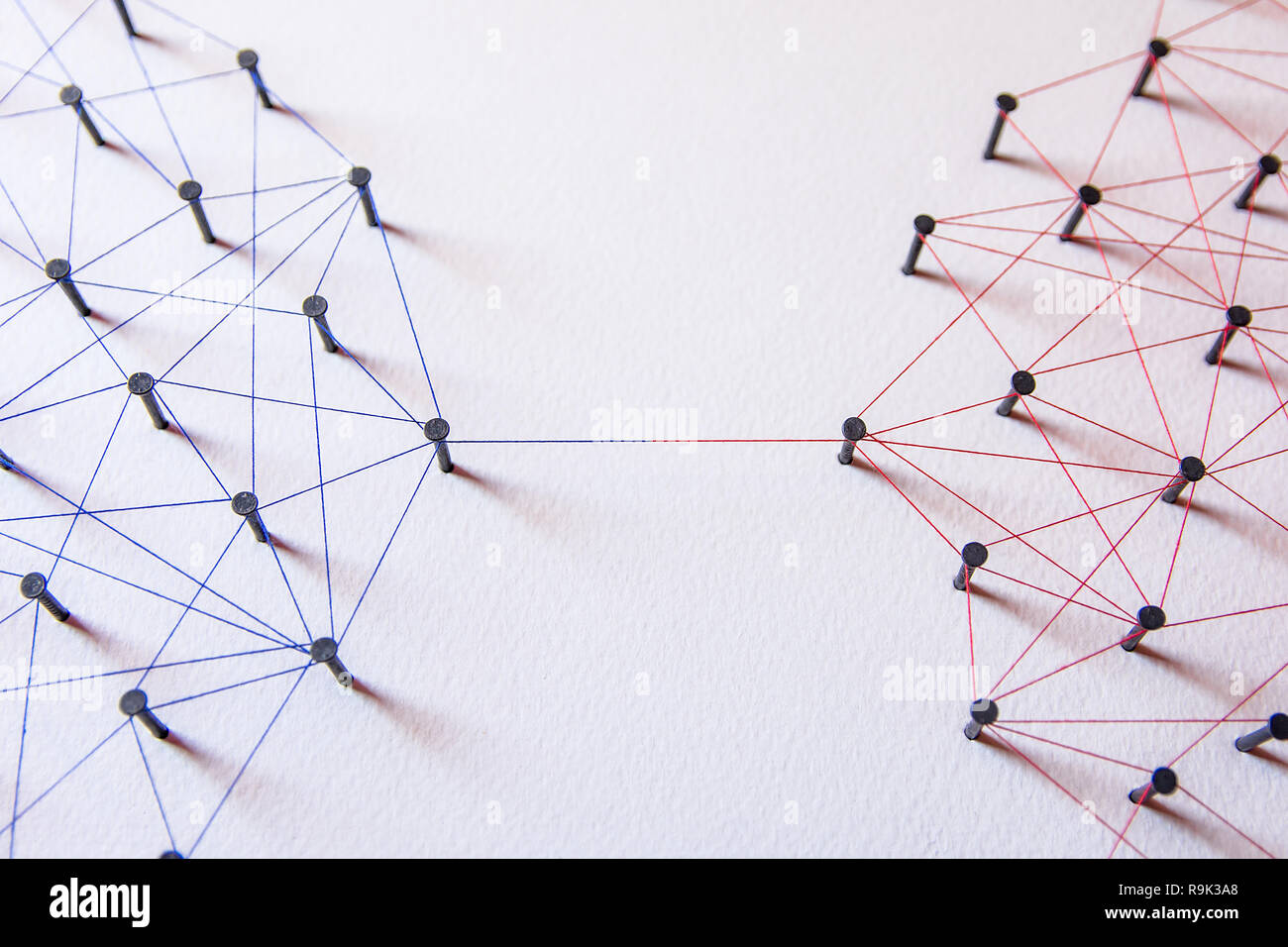 Connecting networks concept - two network connected with yarn red and ...