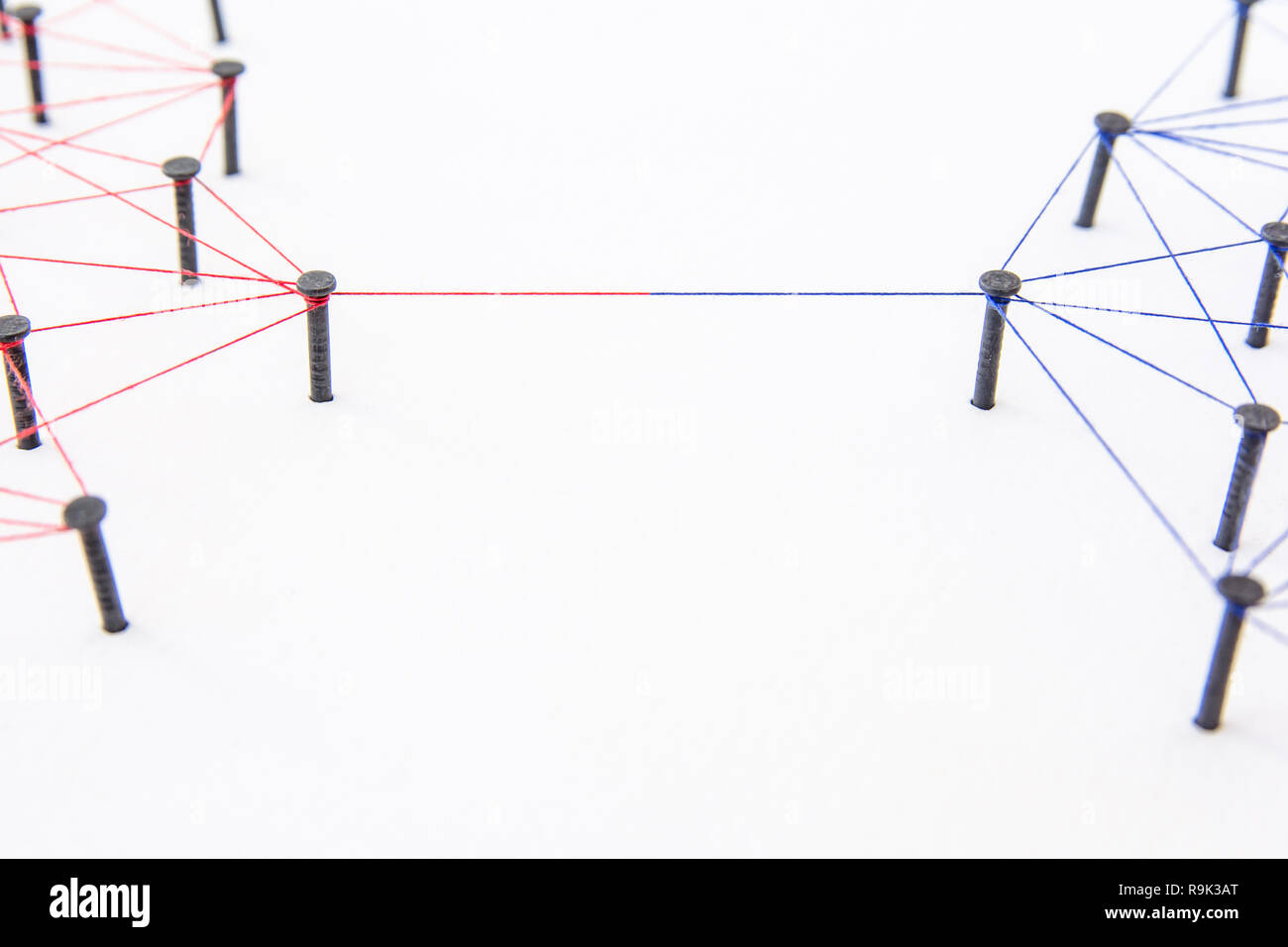 Connecting networks concept - two network connected with yarn red and ...