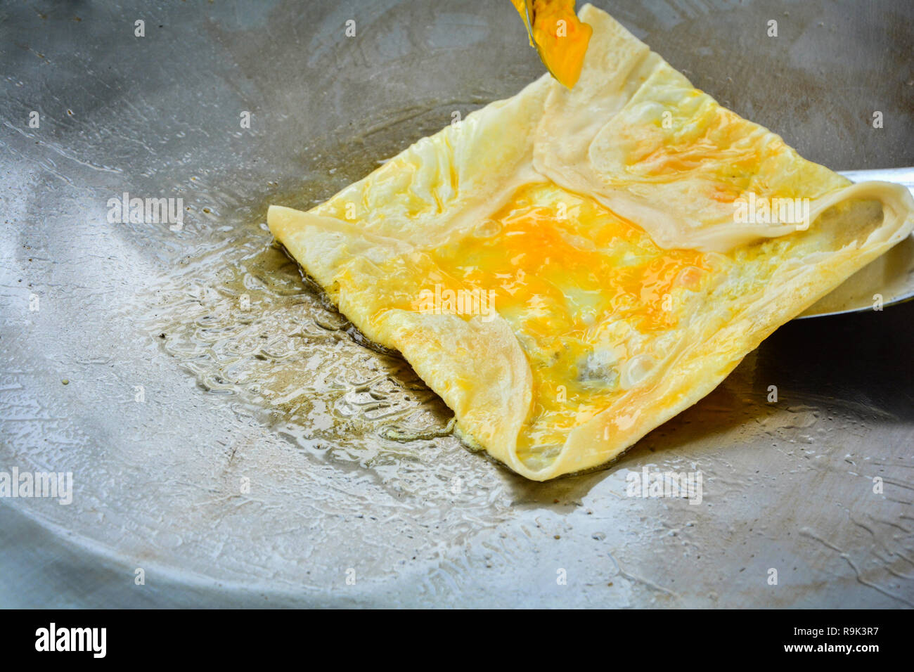 Roti fried on pan - mix egg and roti dough sheet frying wite butter in ...
