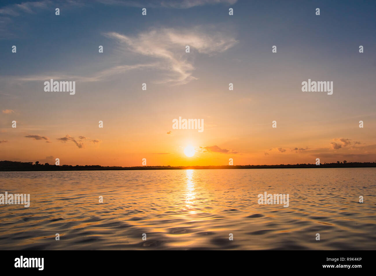 Sunset in the lake. beautiful sunset behind the clouds above the over lake landscape background ...