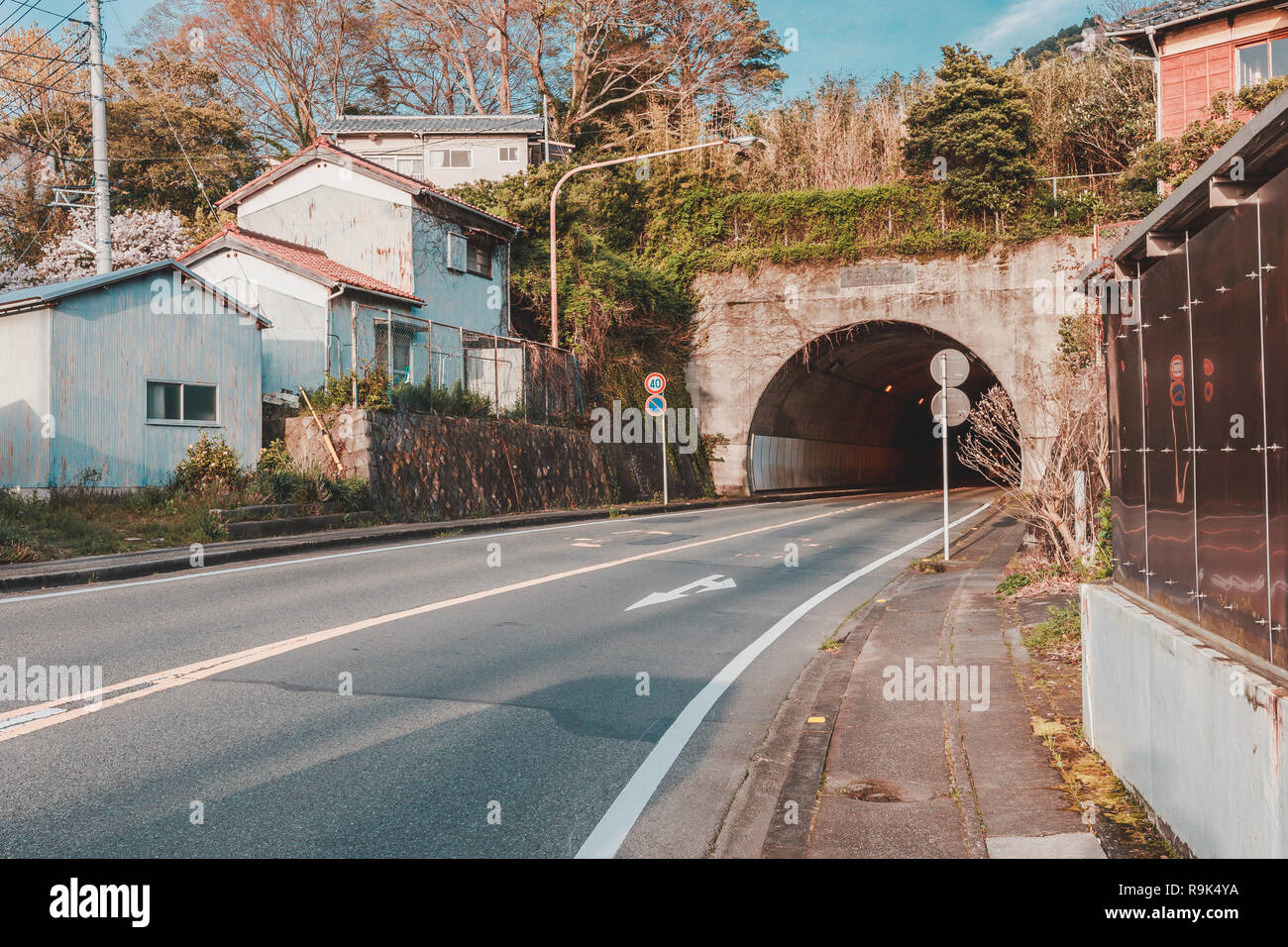 Curved road tunnel in rural area of Japan with house on the side and ...