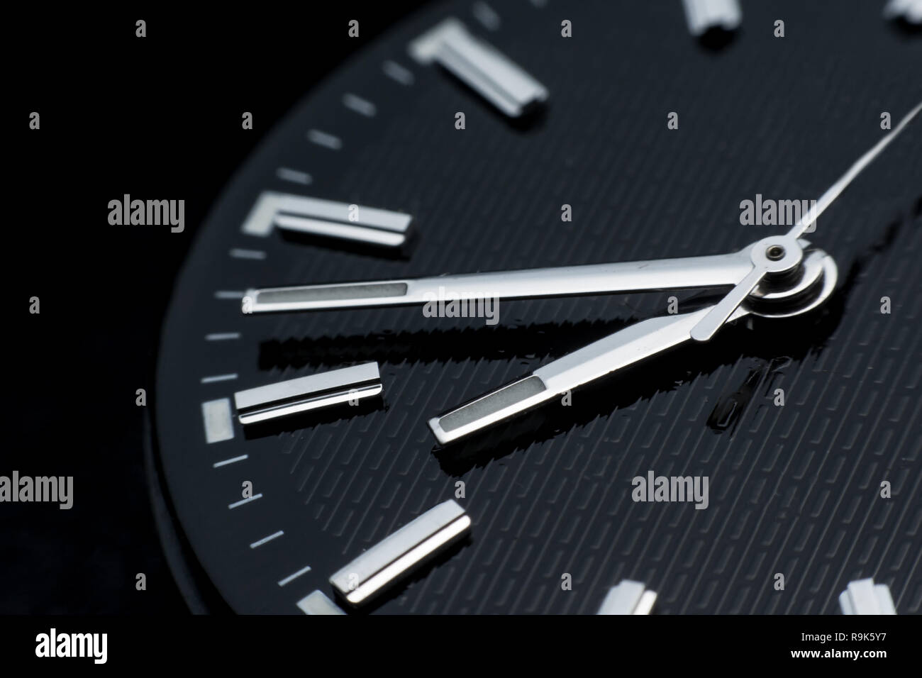 Close up clockwise on black clock face background. Wristwatch in retro ...