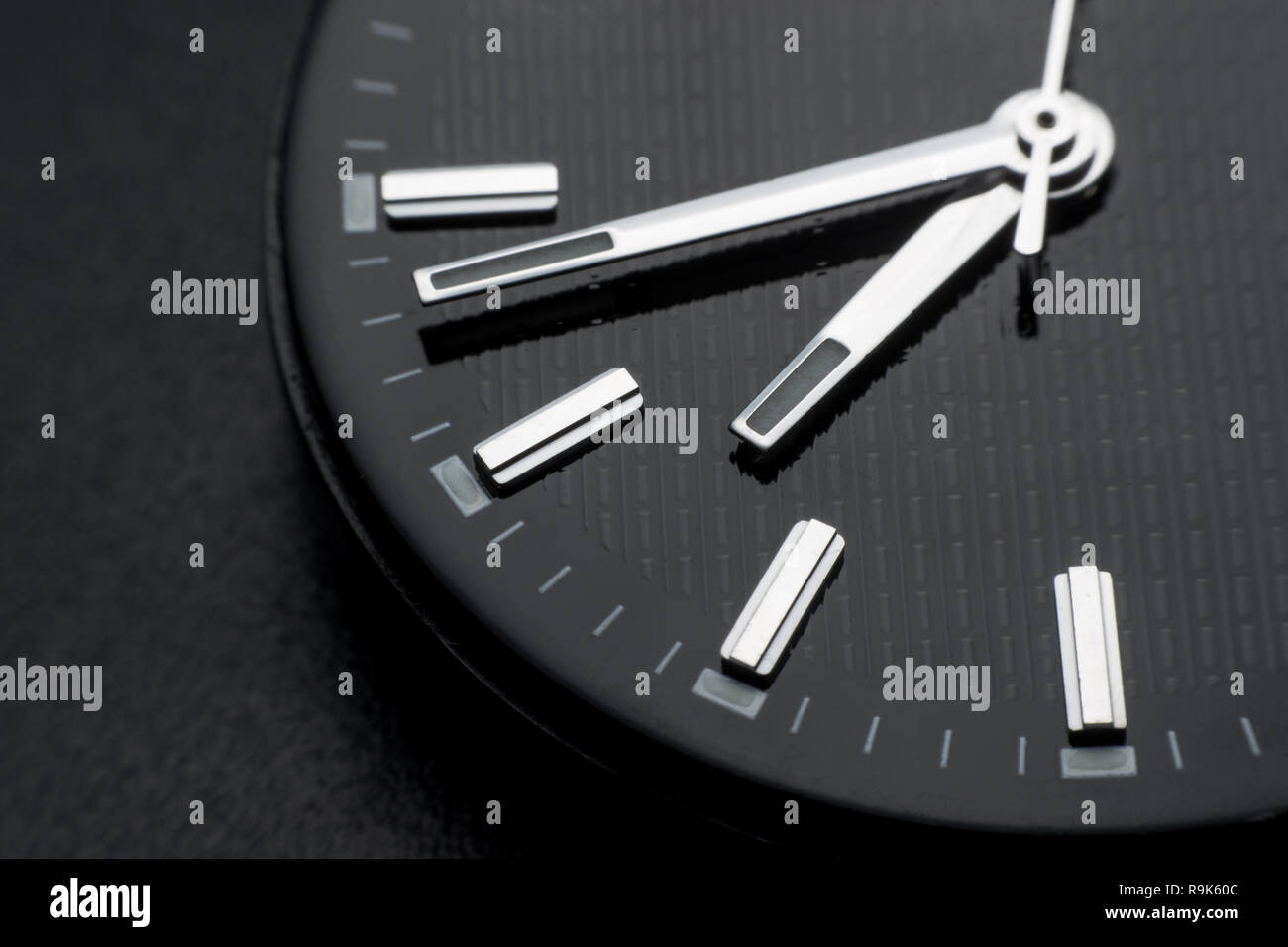Close up clockwise on black clock face background. Wristwatch in retro ...
