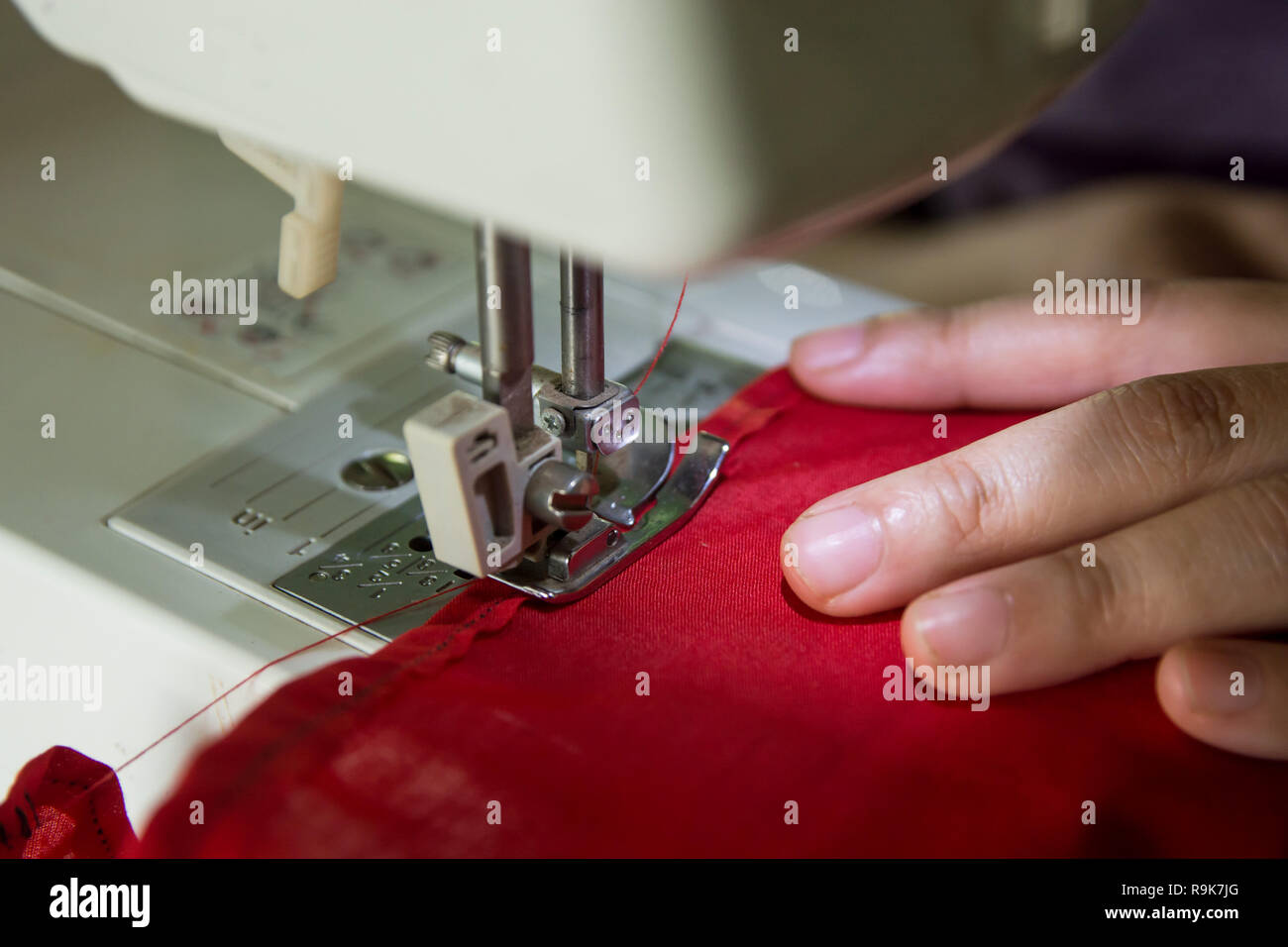 Woman seamstress working making clothes on a sewing machine Stock Photo ...