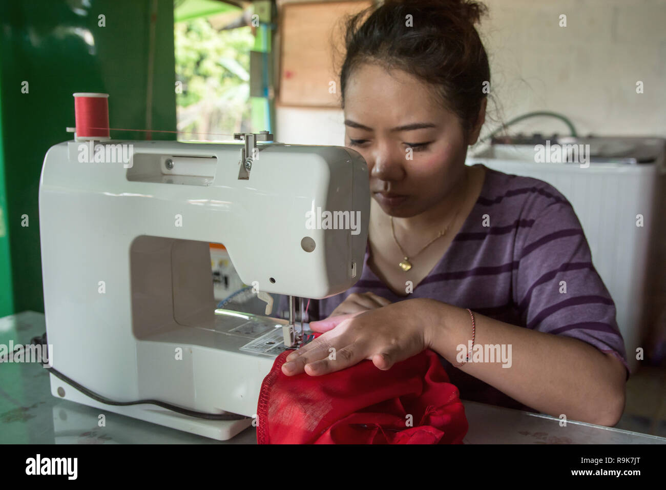 Woman seamstress working making clothes on a sewing machine Stock Photo ...