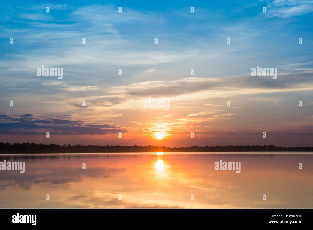 Sunset in the lake. beautiful sunset behind the clouds above the over ...