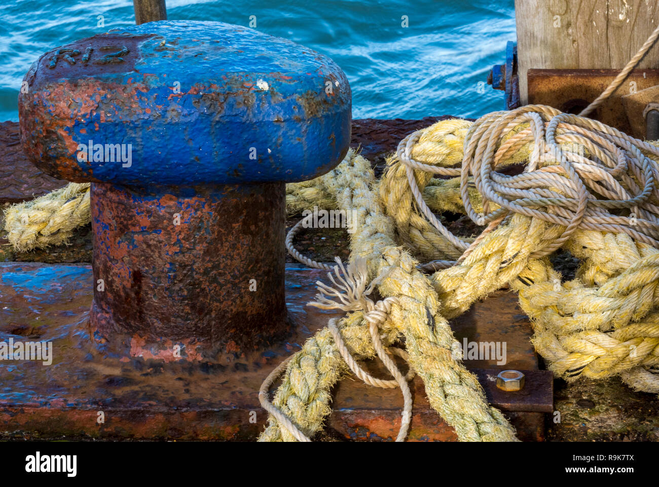nautical and maritime ropes and wires around a large bollard on the ...