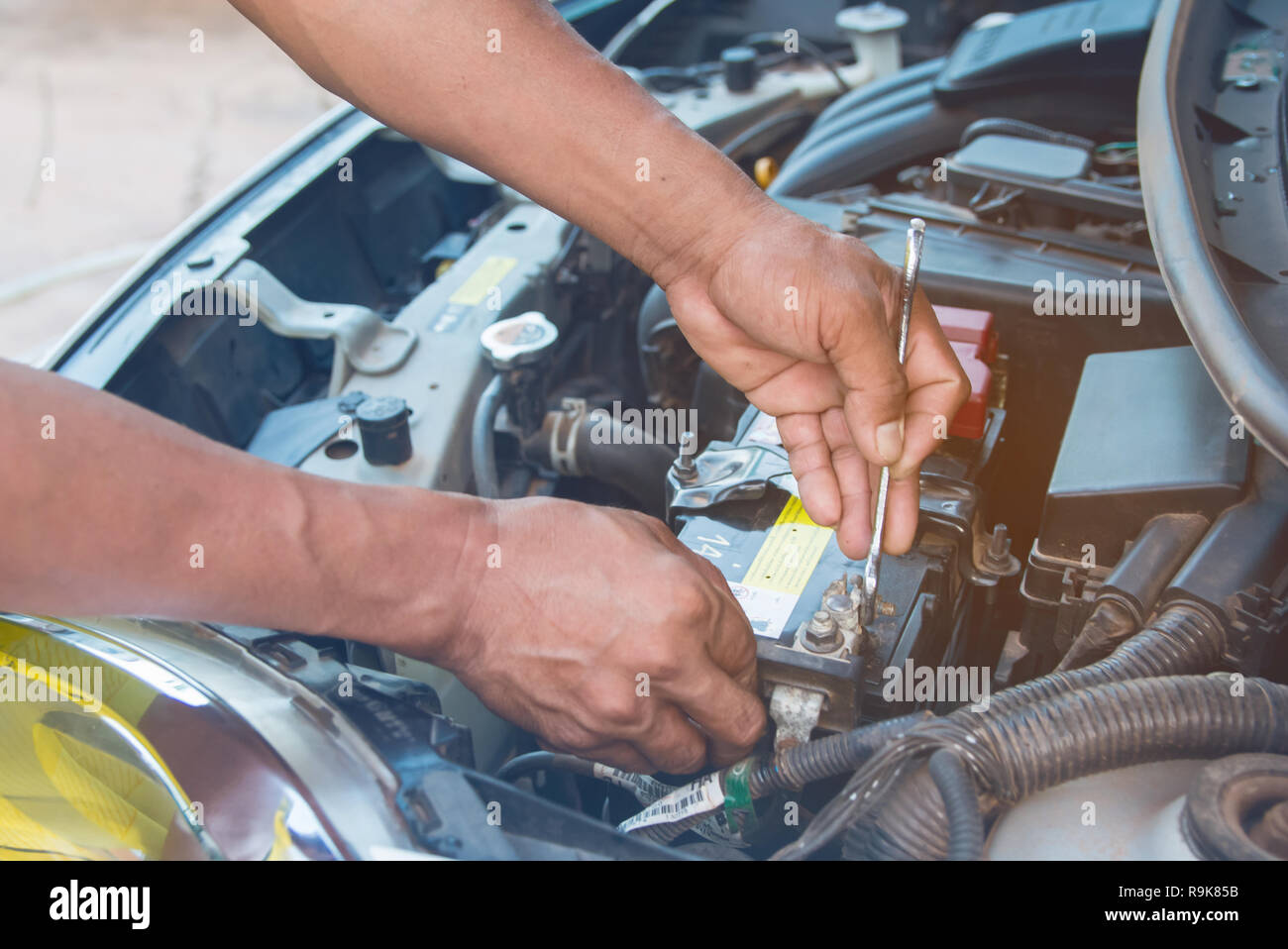 Car mechanic working Install battery with wrench in garage. Repair ...