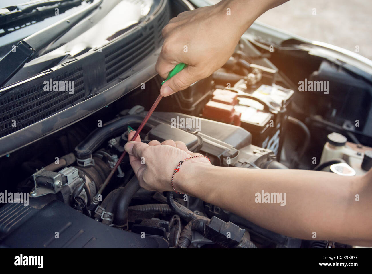 Car mechanic working with screwdriver in garage. Repair service Stock ...