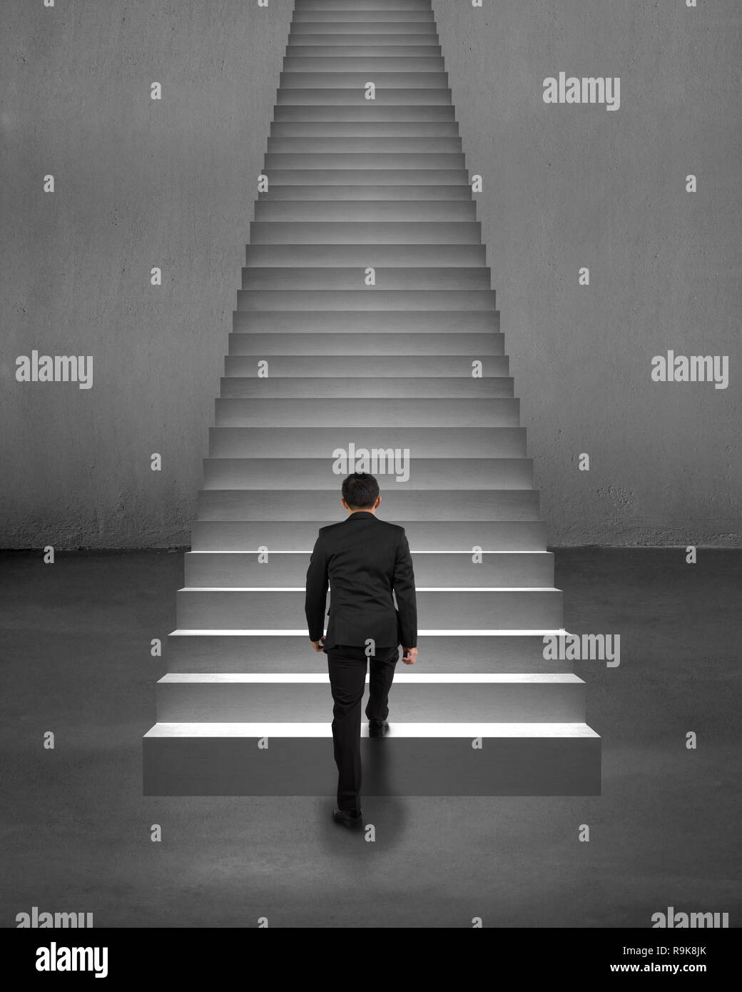 Rear view businessman climbing on stairs with spot lighting and ...