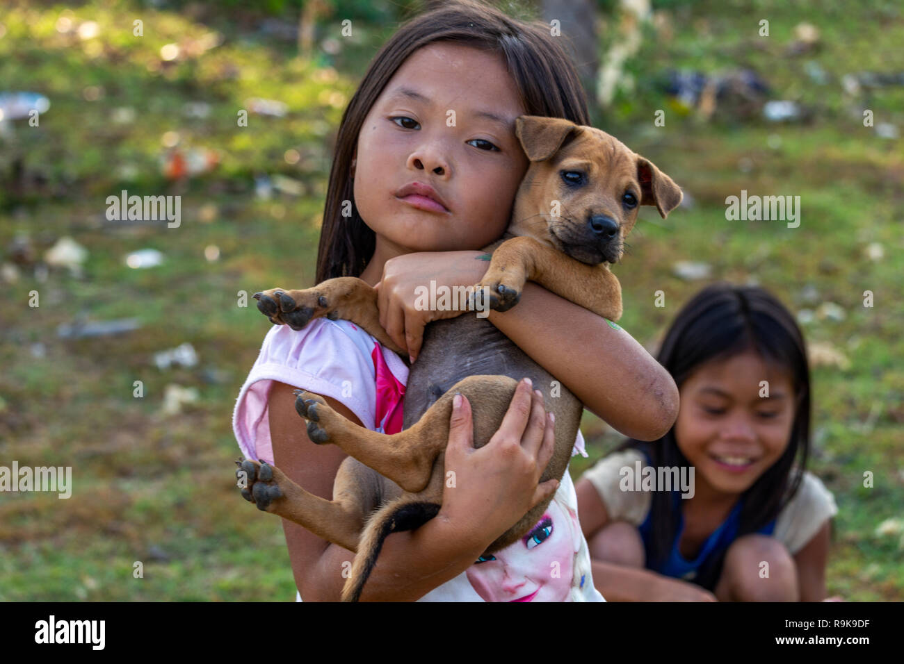 Thakhek, Laos - April 19 2018: Local girls holding a dog and posing in ... Thakhek, Laos - April 19 2018: Local girls holding a dog and posing in ...