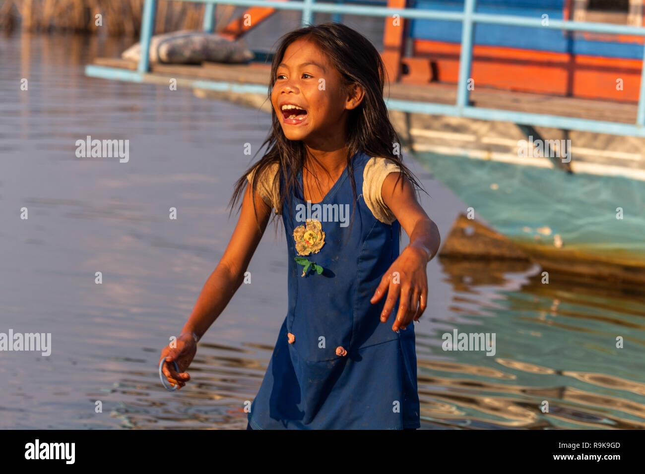 Thakhek, Laos - April 19 2018: Happy girl playing near the water in a ...