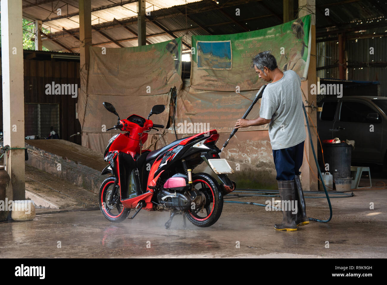 NAKHON PHANOM, THAILAND - OCT 11, 2018 : Old man wash your motorcycle ...