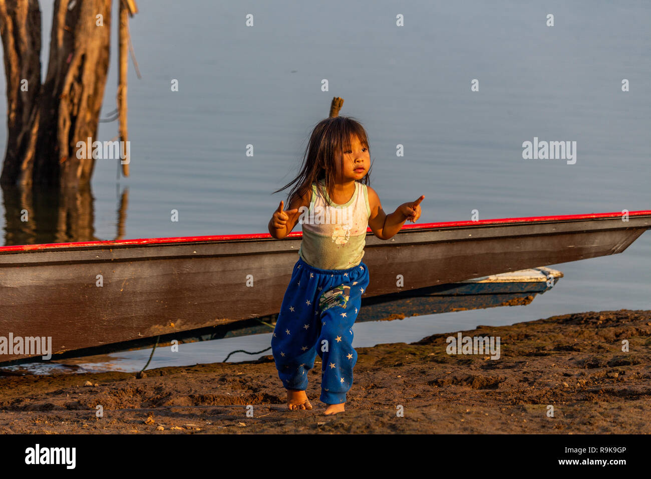 Thakhek, Laos - April 19 2018: Happy girl playing near the water in a ...