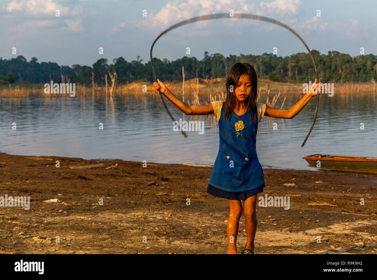 Thakhek, Laos - April 19 2018: Local girl jumping over a rudimentary ...