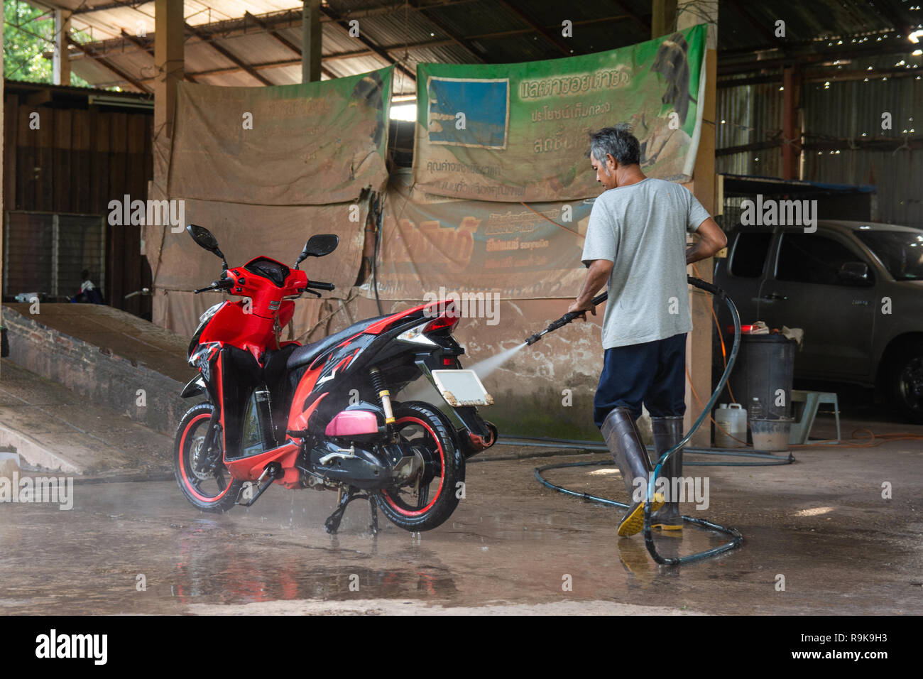 NAKHON PHANOM, THAILAND - OCT 11, 2018 : Old man wash your motorcycle ...