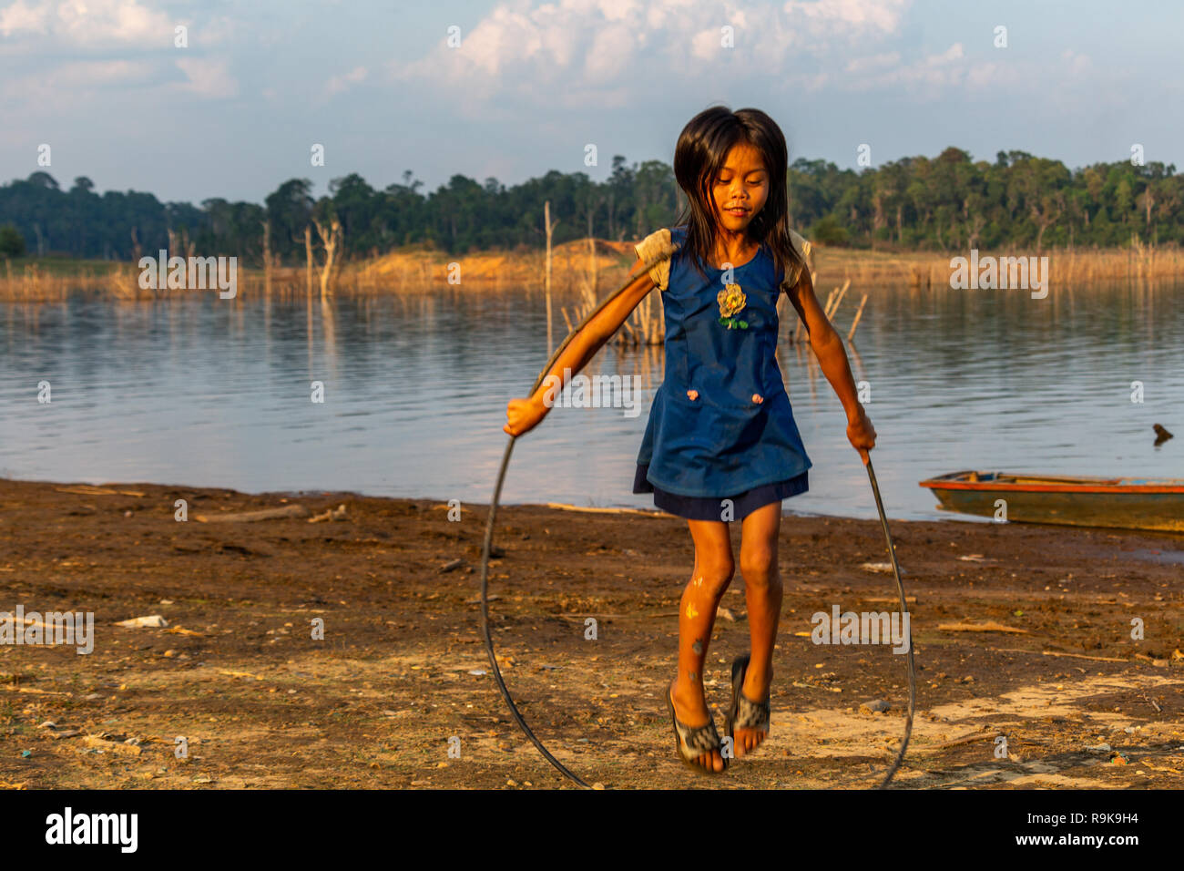 Thakhek, Laos - April 19 2018: Local girl jumping over a rudimentary ... Thakhek, Laos - April 19 2018: Local girl jumping over a rudimentary ...