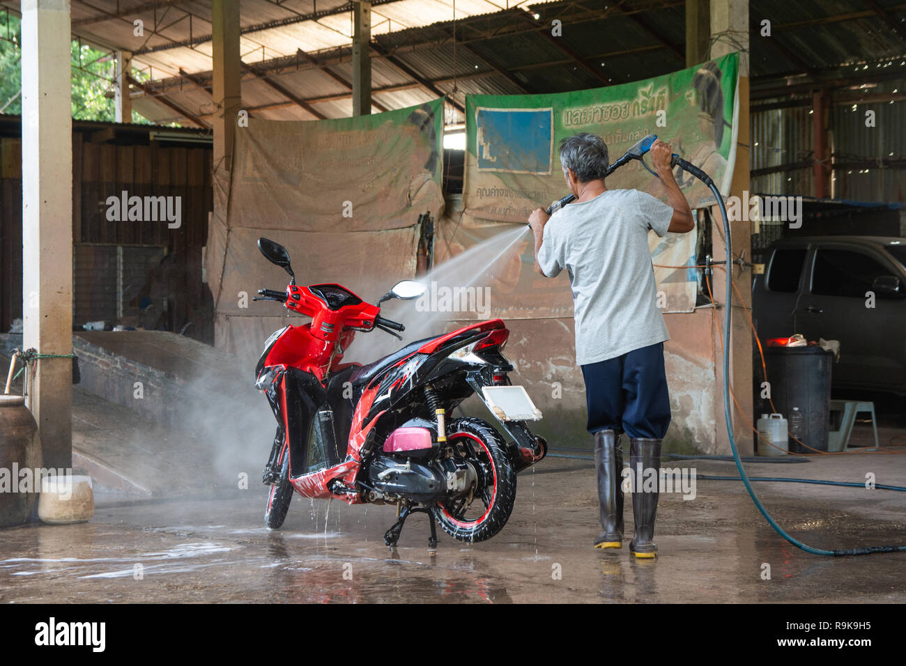 NAKHON PHANOM, THAILAND - OCT 11, 2018 : Old man wash your motorcycle ...