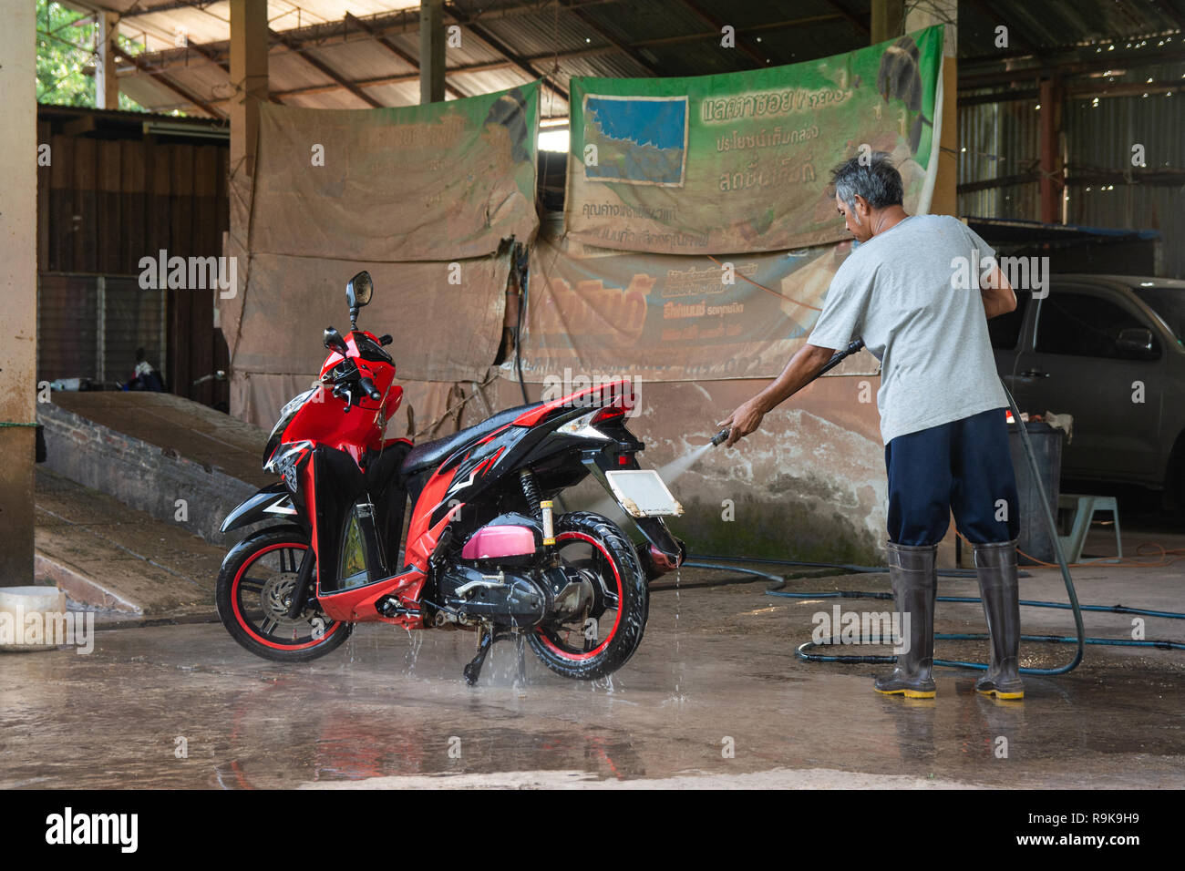 NAKHON PHANOM, THAILAND - OCT 11, 2018 : Old man wash your motorcycle ...