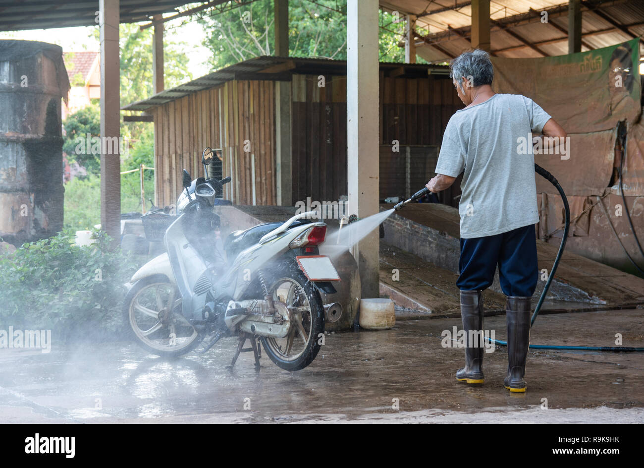 Old man wash your motorcycle with High Pressure Washer at car wash shop ...
