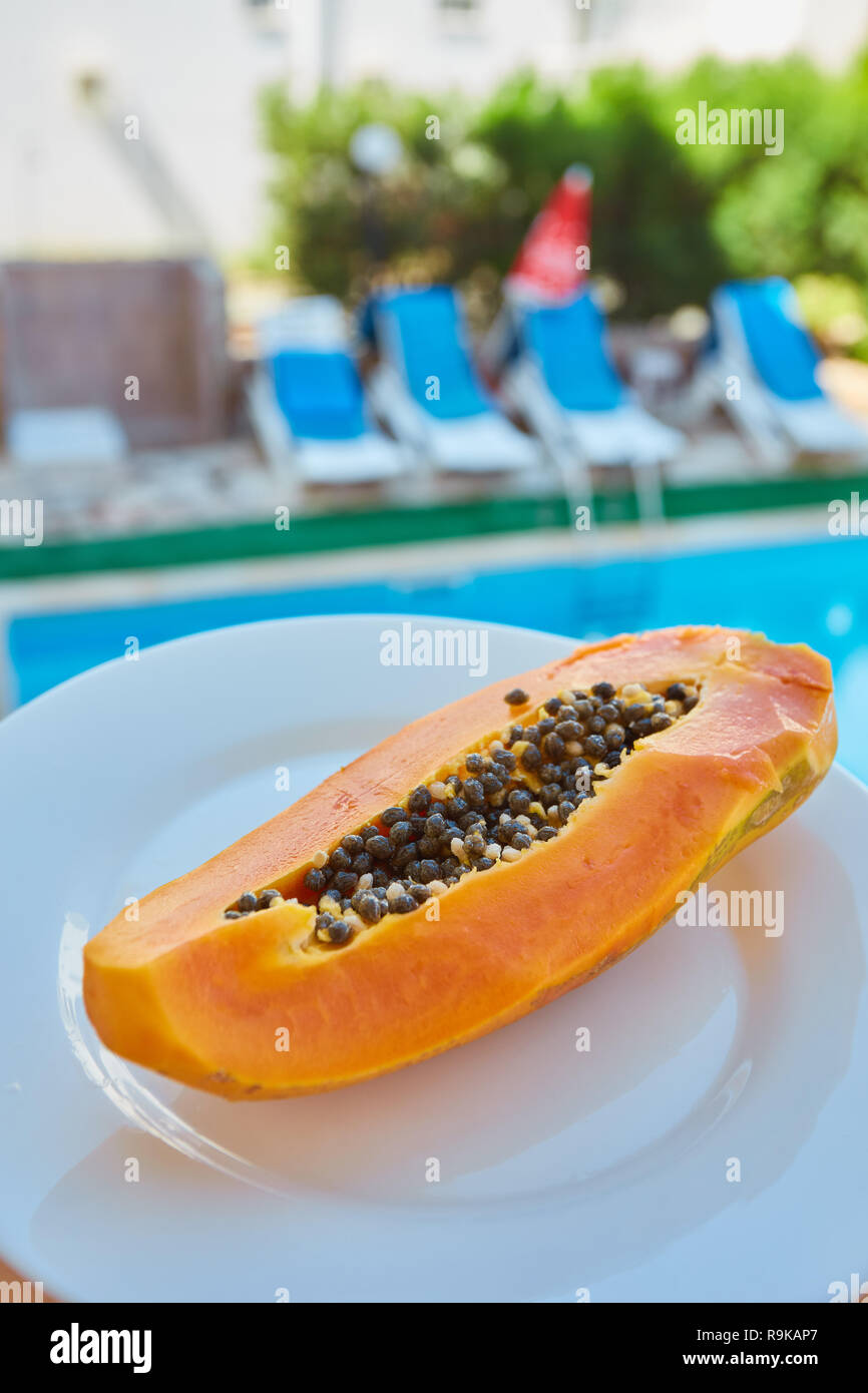 papaya fruit half and cut pieces close up photo on the plate Stock ...