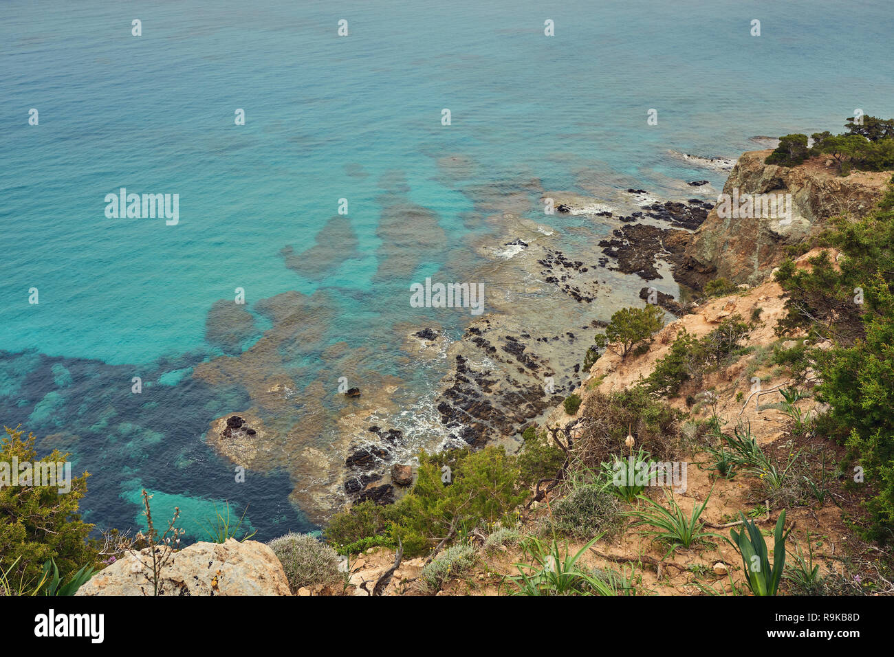 Stones and rocks in forefront with creamy surf ebbing and flowing on ...