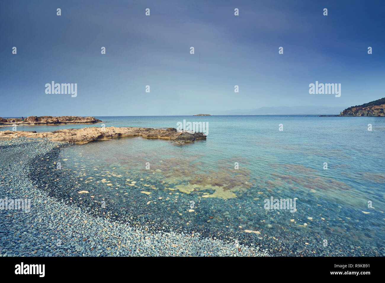 Stones and rocks in forefront with creamy surf ebbing and flowing on ...