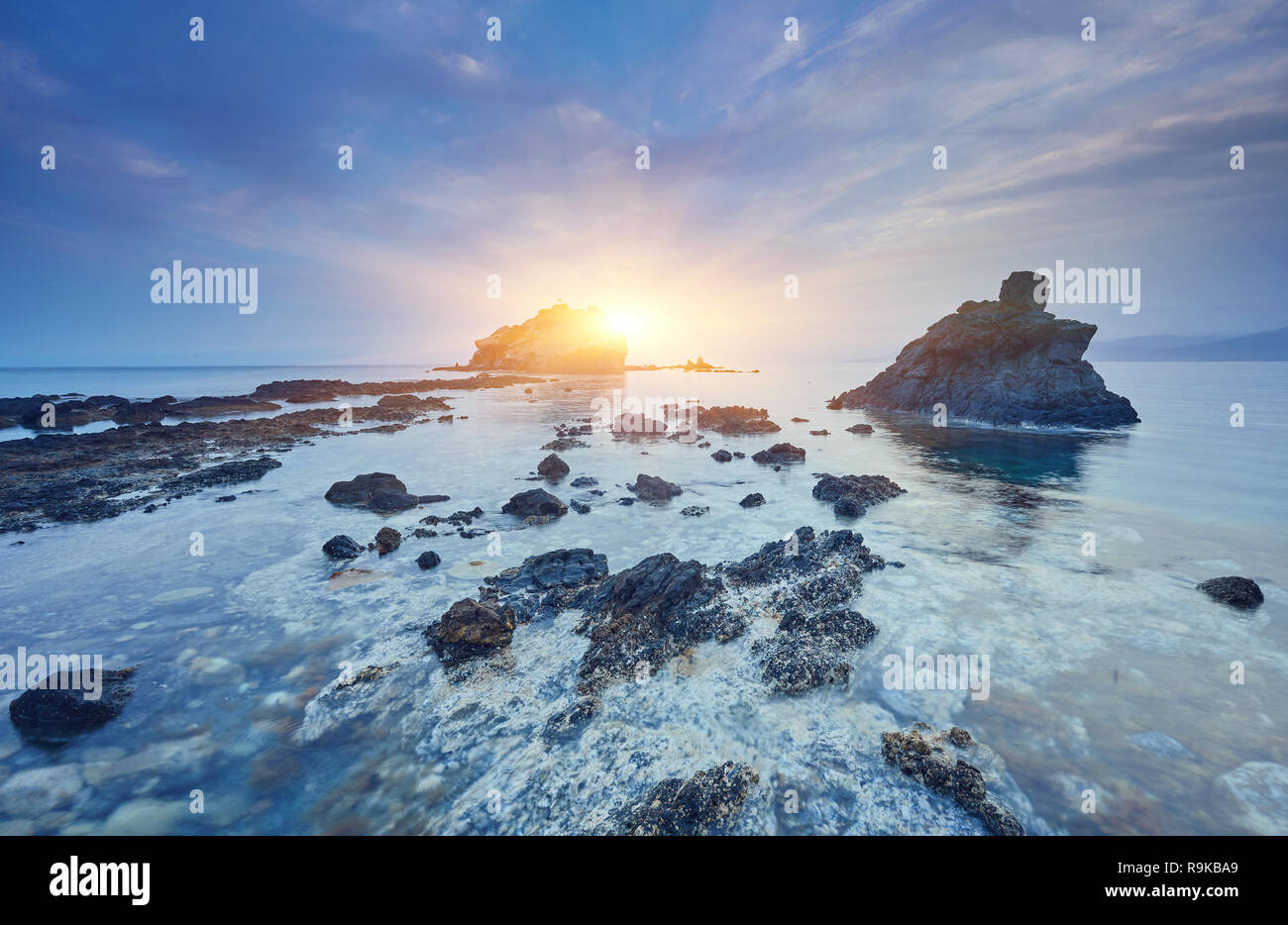 Stones and rocks in forefront with creamy surf ebbing and flowing on ...