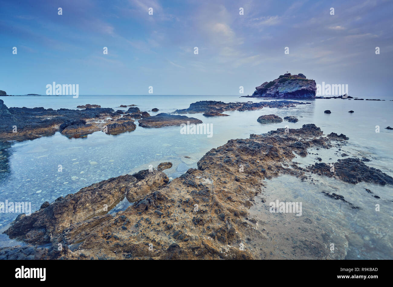 Stones and rocks in forefront with creamy surf ebbing and flowing on ...