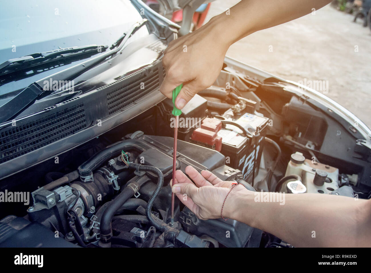 Car mechanic working with screwdriver in garage. Repair service Stock ...