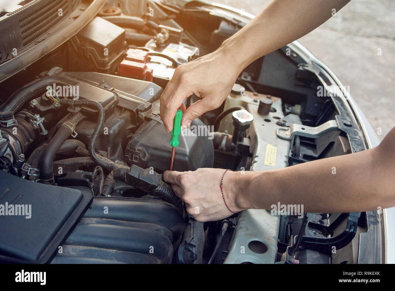 Car mechanic working with screwdriver in garage. Repair service Stock ...