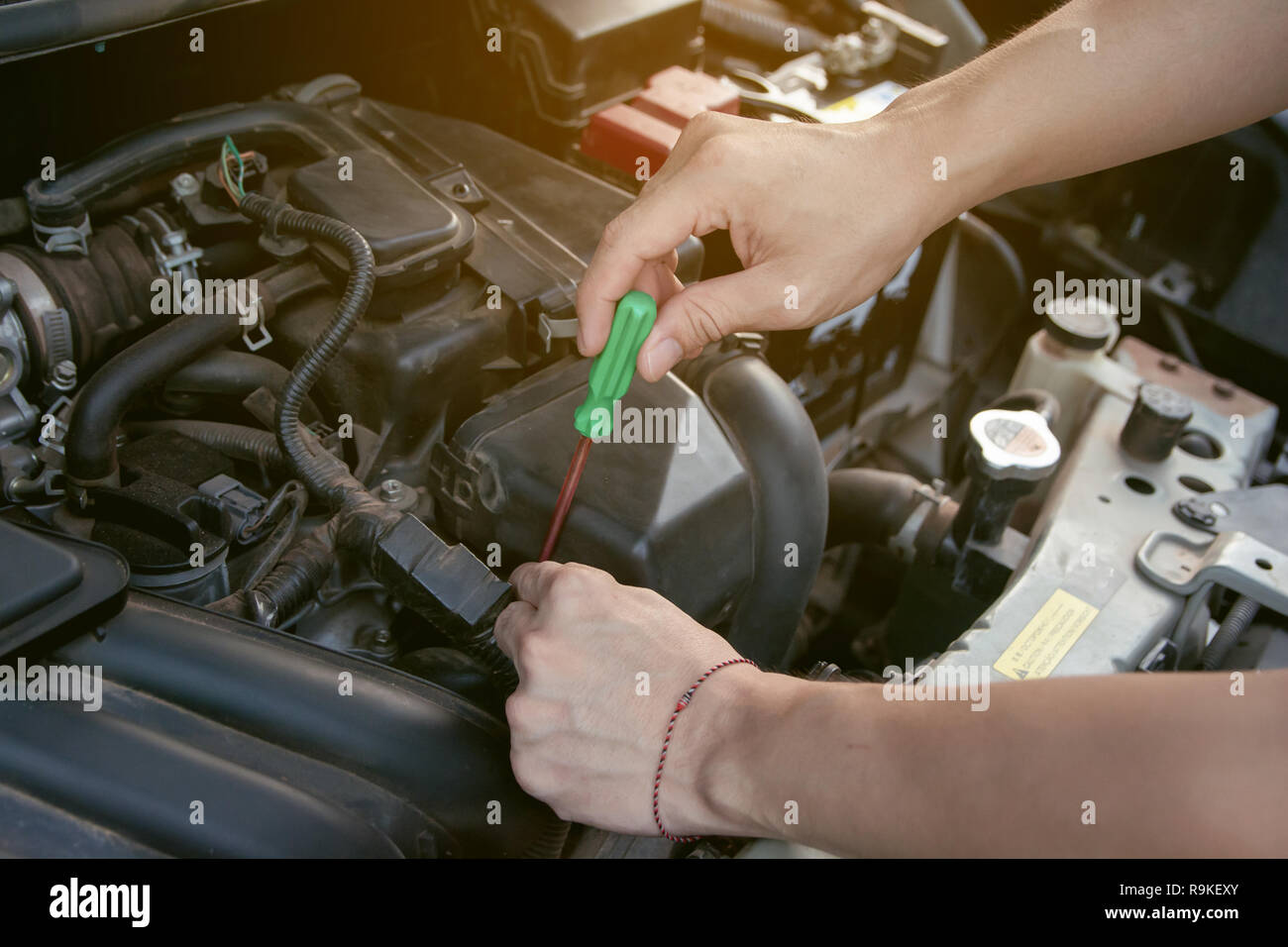 Car mechanic working with screwdriver in garage. Repair service Stock ...