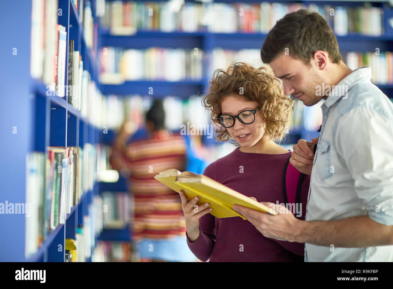 Young students reading book together Stock Photo - Alamy