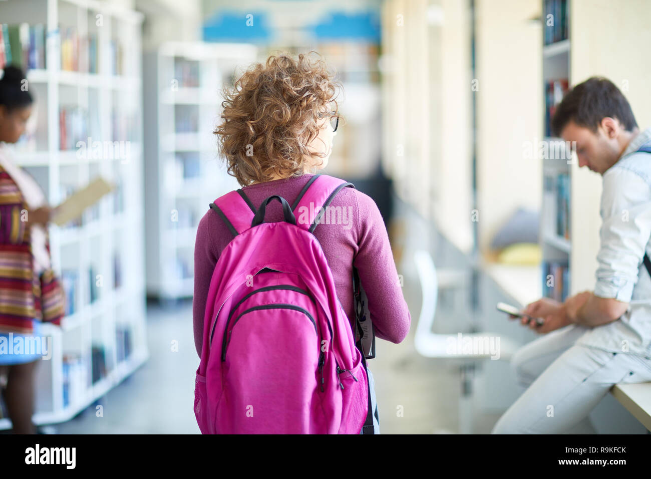 Student girl walking over library corridor Stock Photo - Alamy