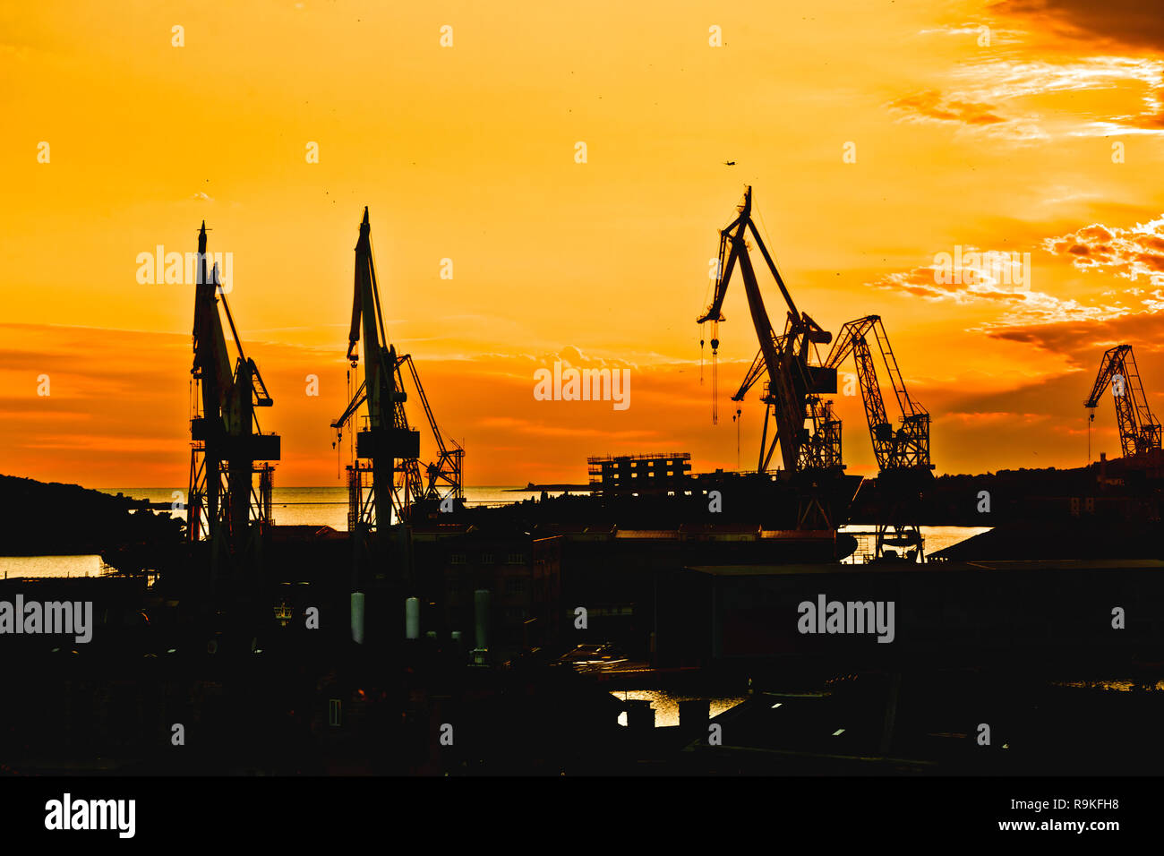 Town of Pula shipyard cranes sunset silhouette view, Istria region of ...