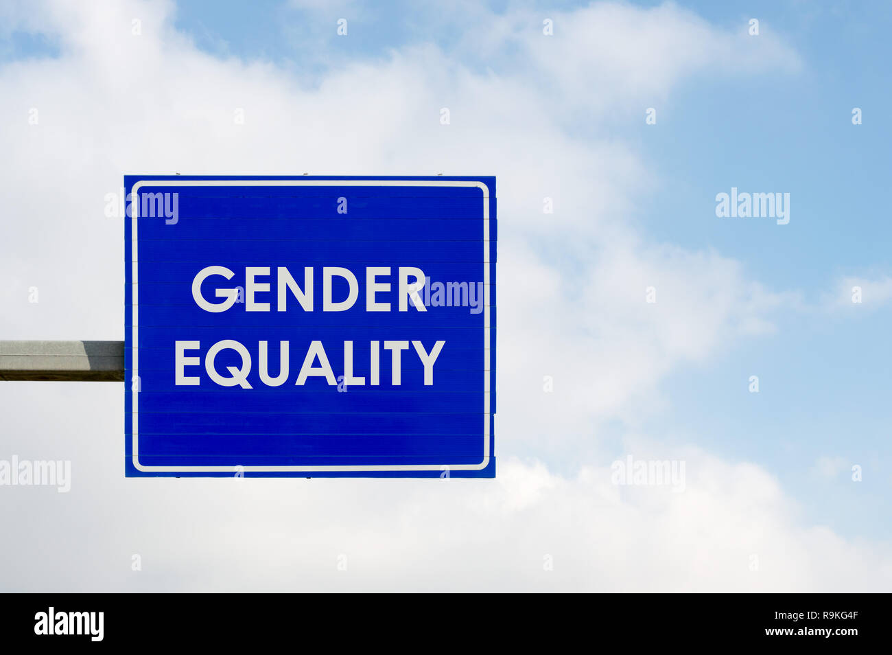 Blue road sign displaying Gender Equality words on blue sky and white ...