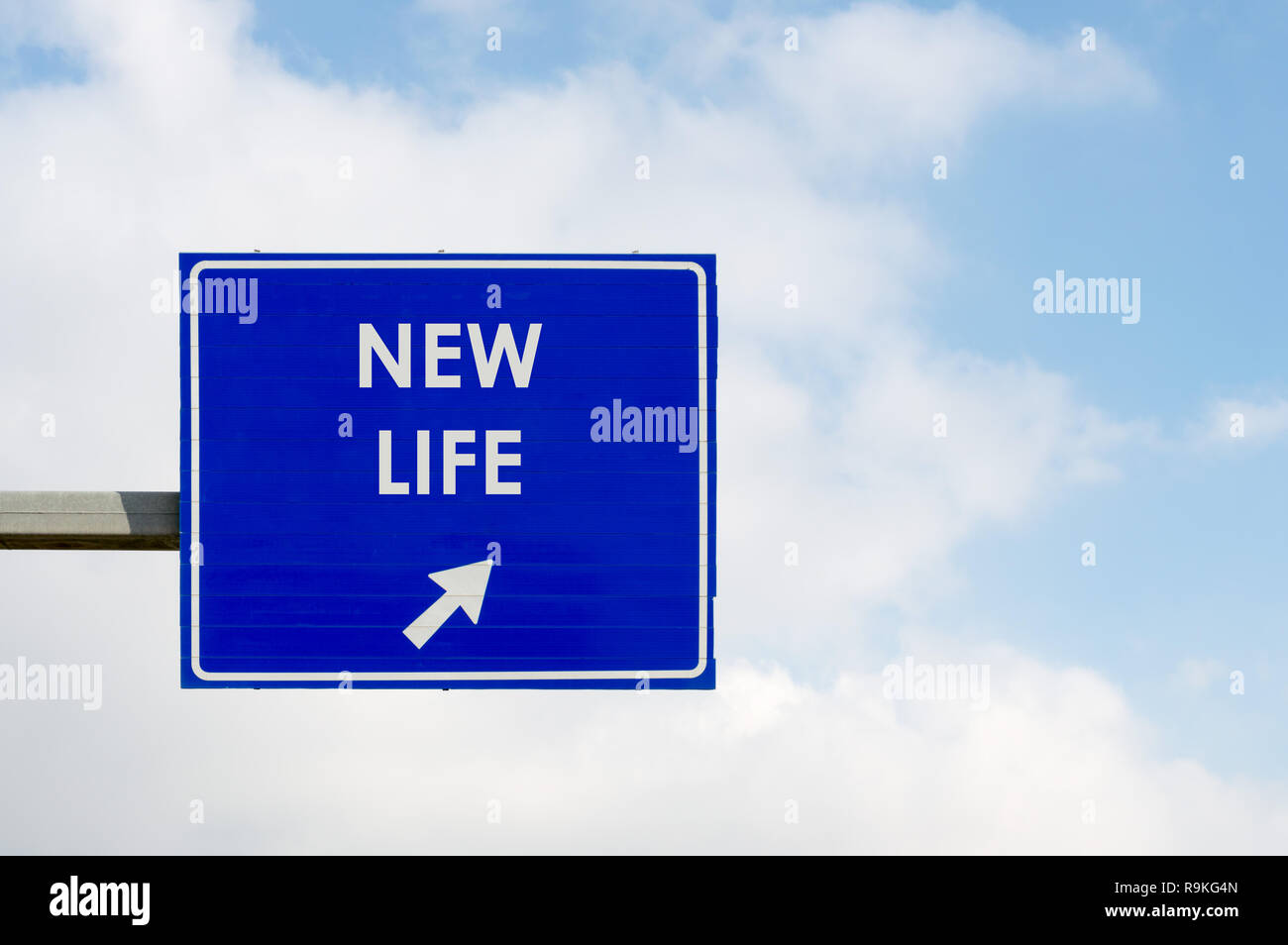 Blue road sign displaying New Life words on blue sky and white clouds ...